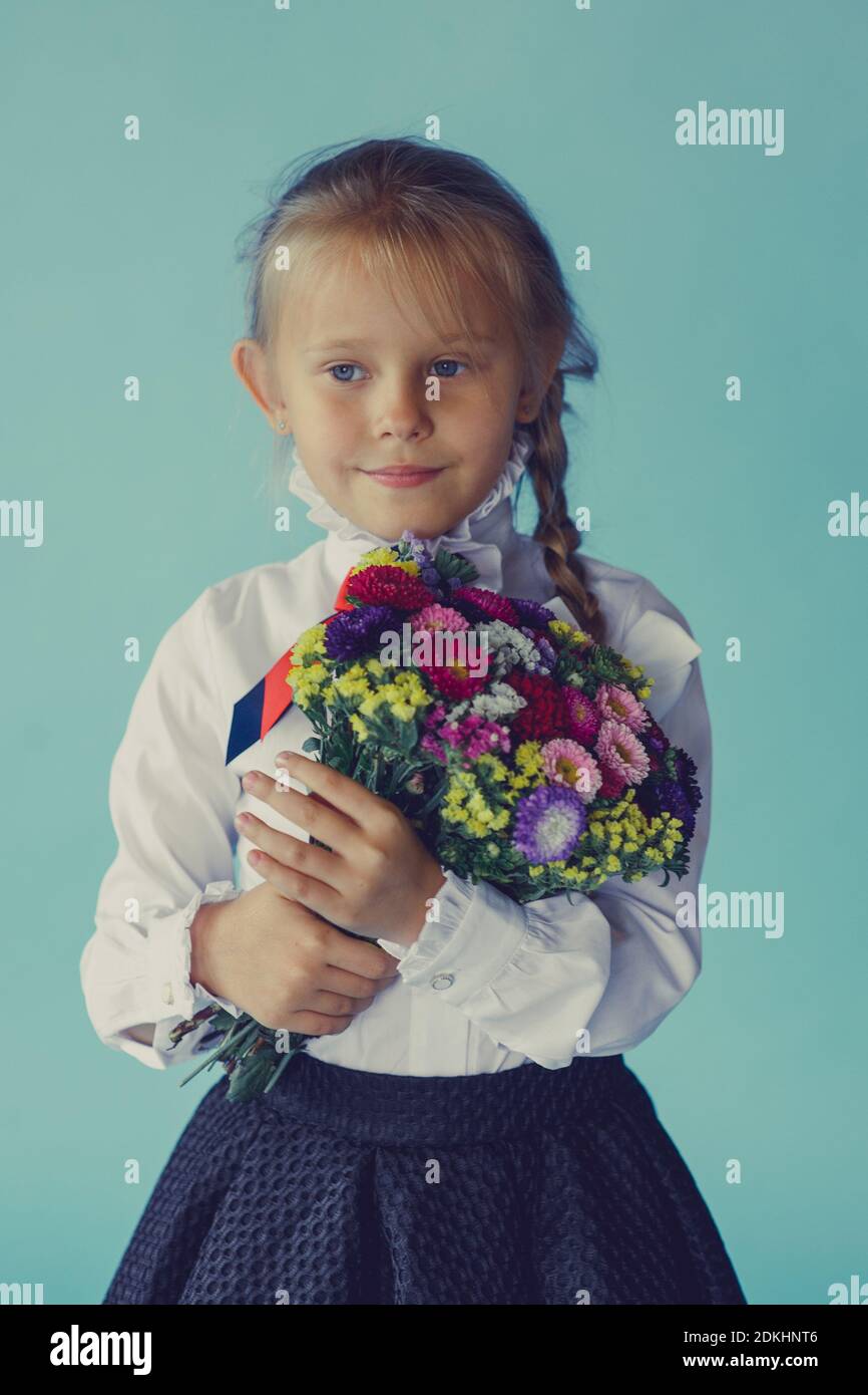 Schoolgirl on blue background. Girl in a school skirt and blouse on a ...