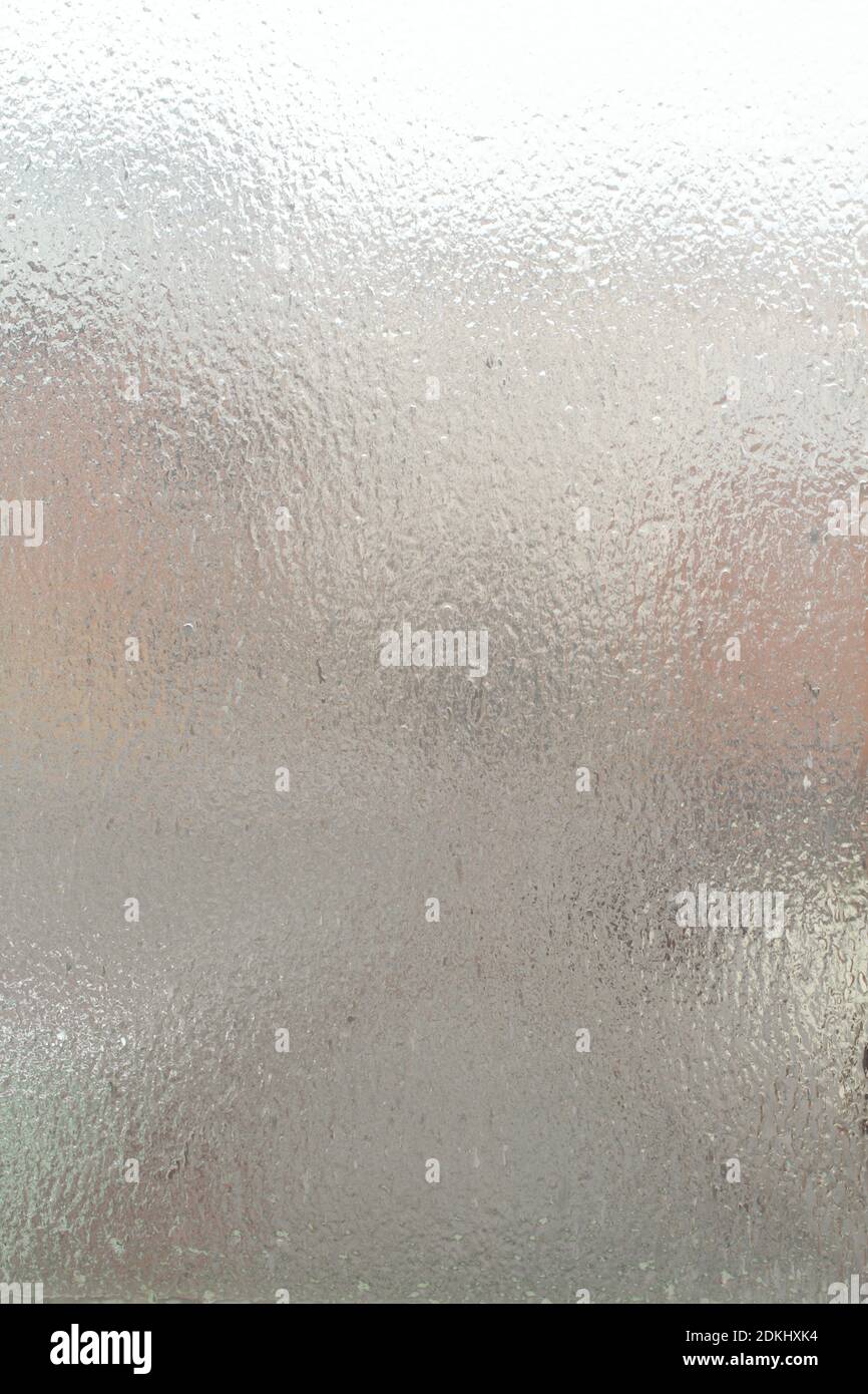 Street view through an ice-covered window outside. Dull cloudy winter ...