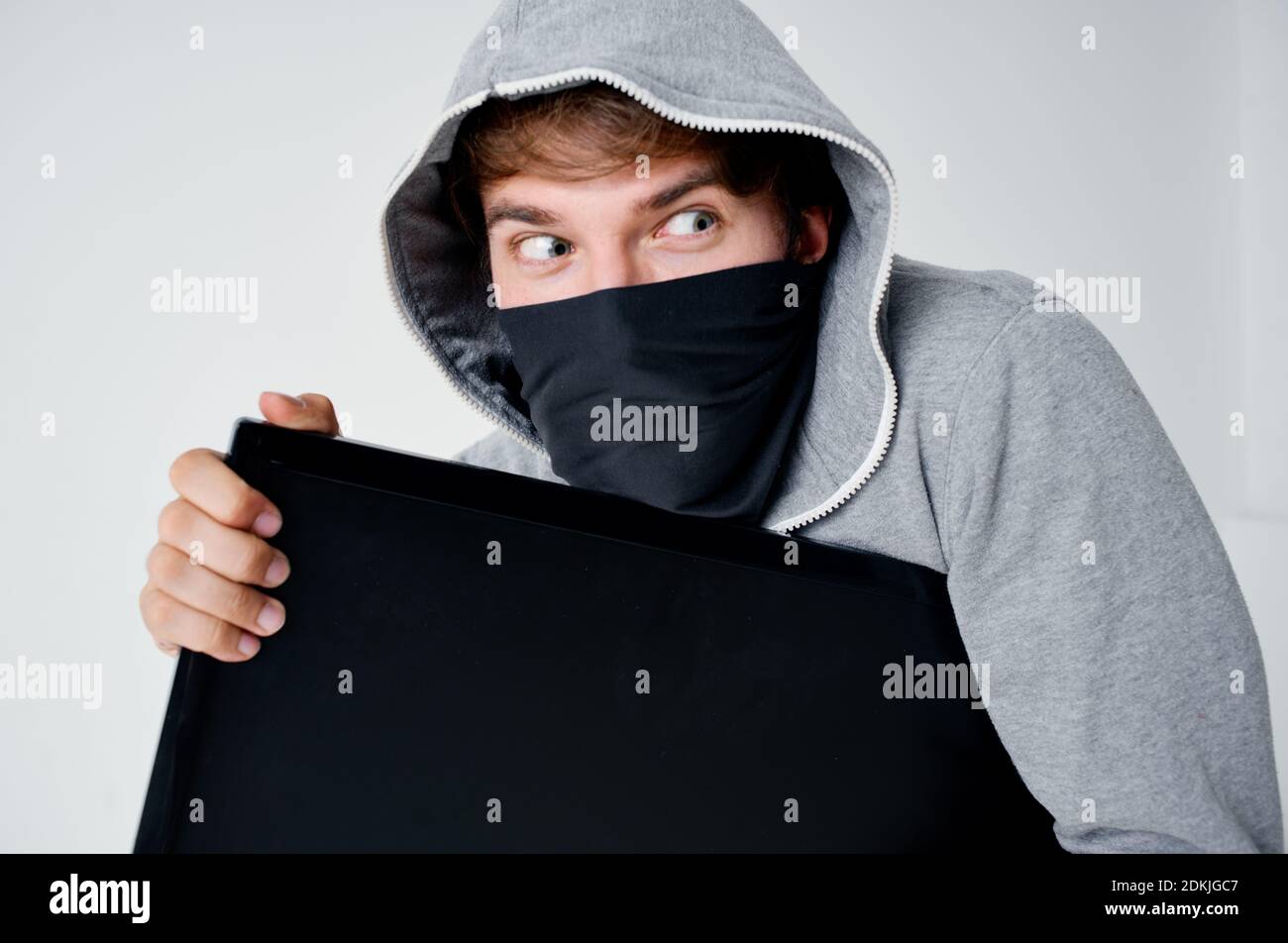 a man in a gray hoodie disguise theft technique hacker Stock Photo - Alamy