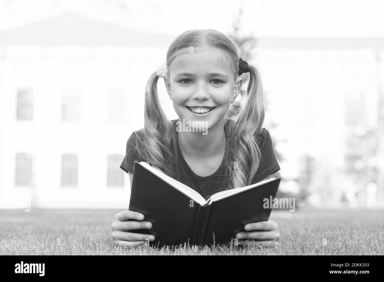 Open your imagination, read. Happy kid read book on green grass ...
