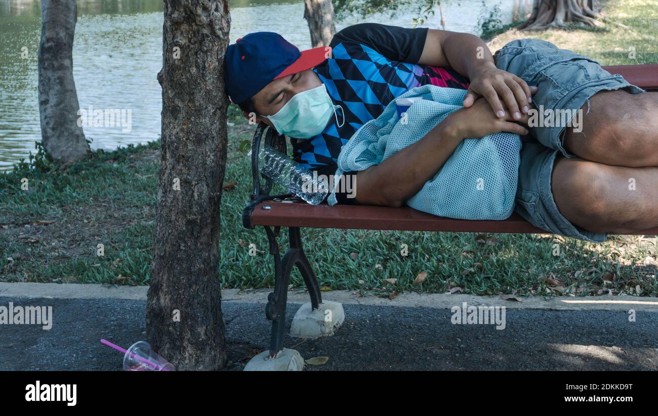 Man Sleeping On Bench At Park Stock Photo - Alamy
