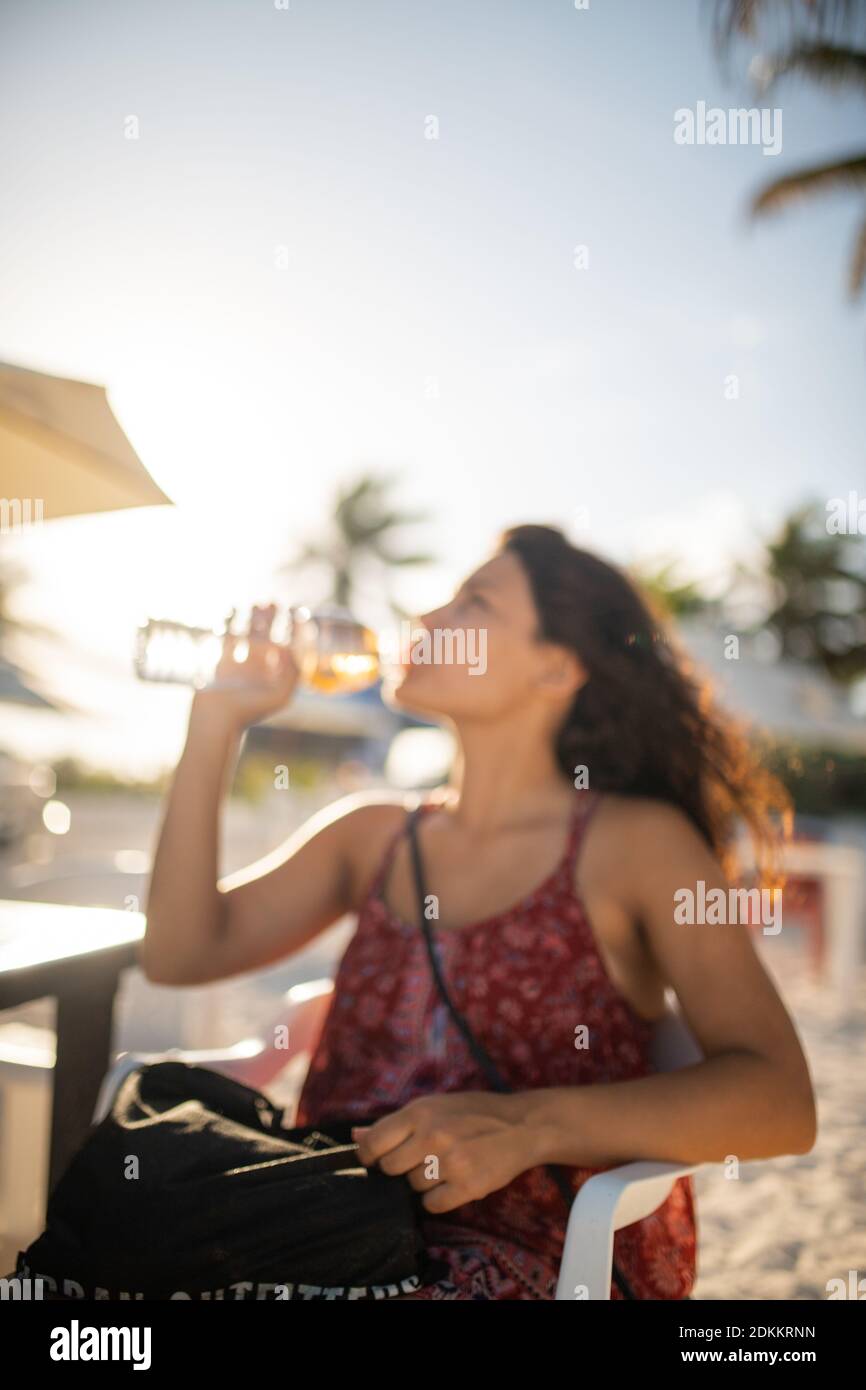 Woman on the beach drinking water from a bottle Stock Photo - Alamy