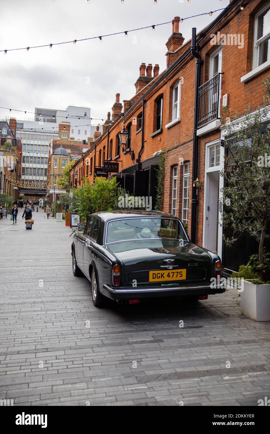 Classic luxury car parked outside a brick house Stock Photo - Alamy