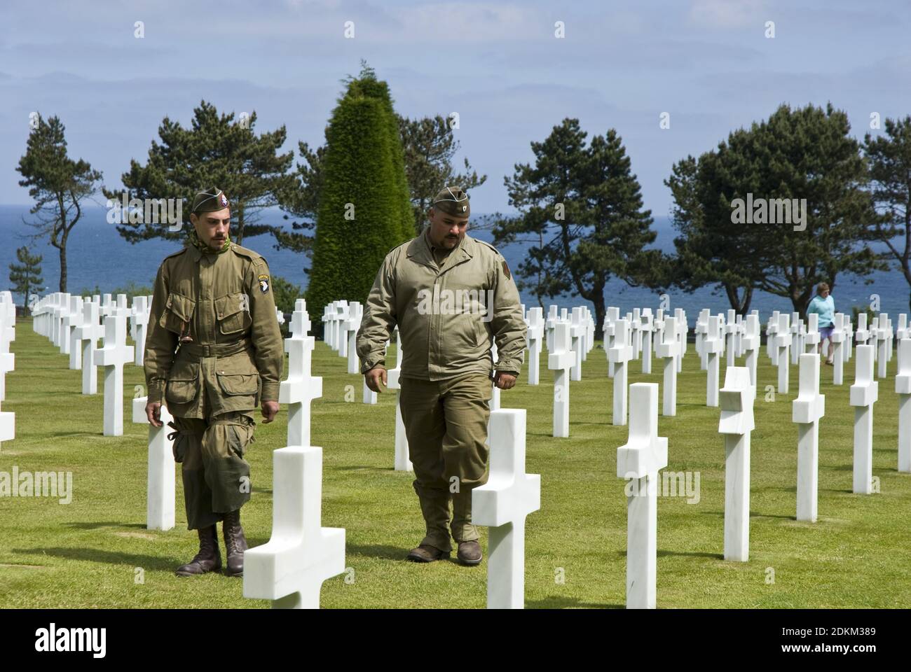 Two historical reenactors in WW2 American army uniforms walk past ...