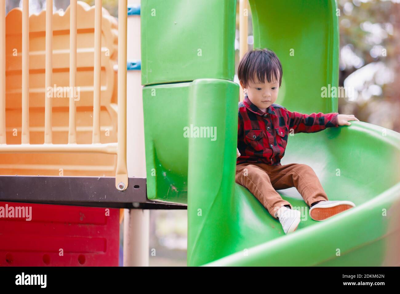 Full Length Of Boy Sitting On Slide At Park Stock Photo - Alamy