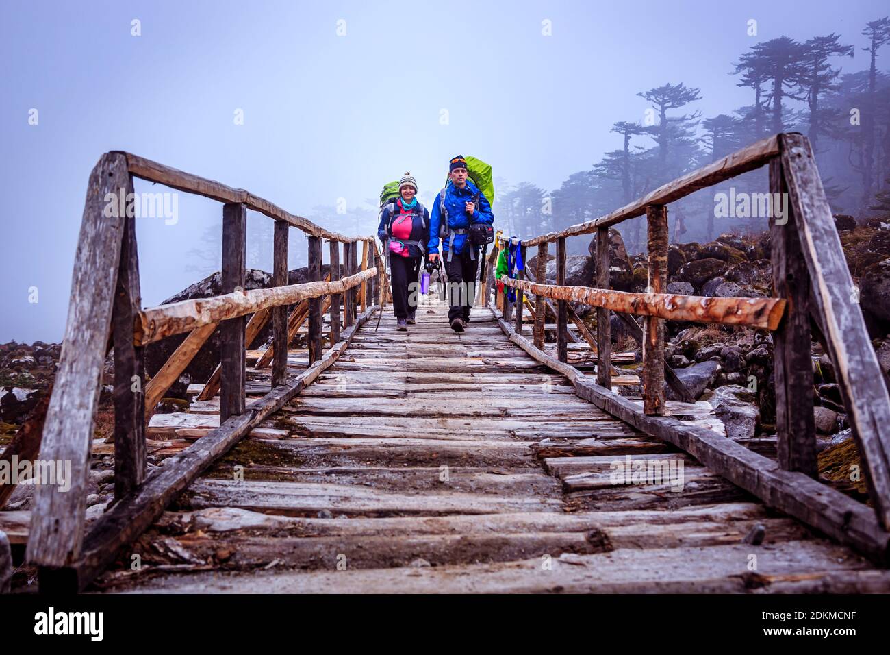 View of two trekkers crossing a wooden bridge on the Gochela trek to ...