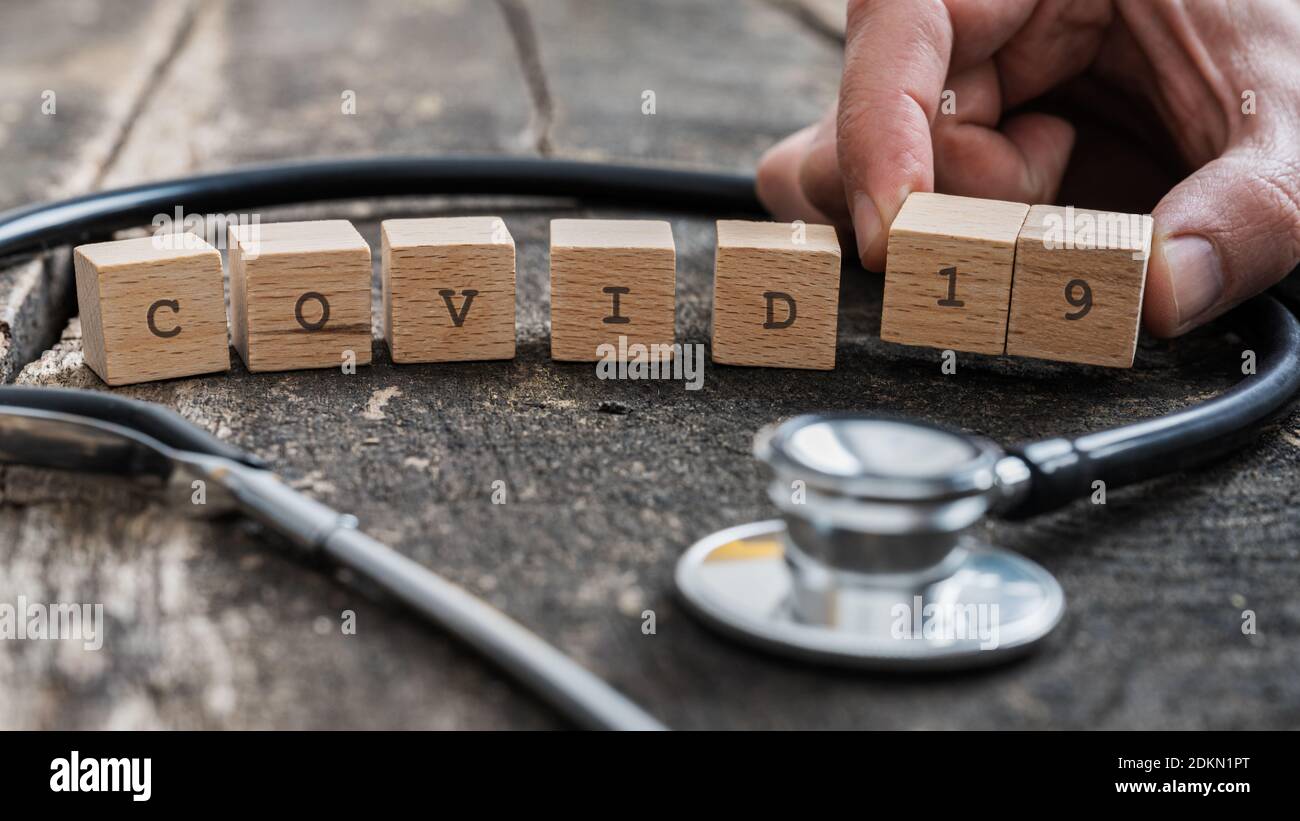 Covid 19 sign on wooden blocks next to a medical stethoscope Stock ...