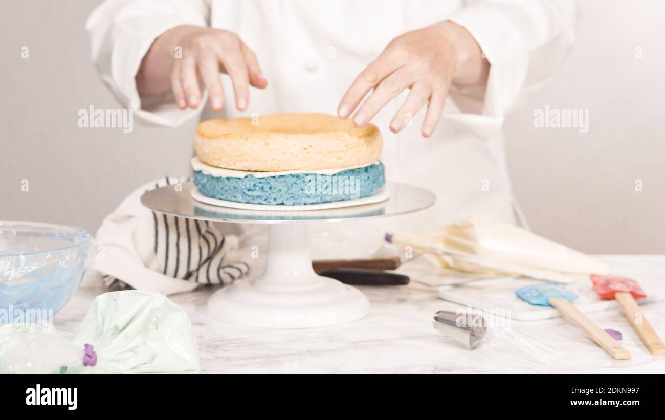 Stacking cake layers to create the round three-layer vanilla cake Stock ...