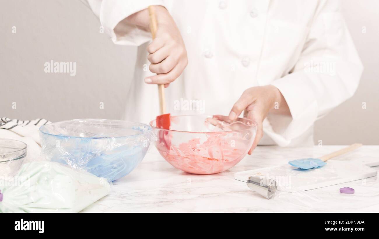 Mixing food coloring with buttercream frosting Stock Photo - Alamy