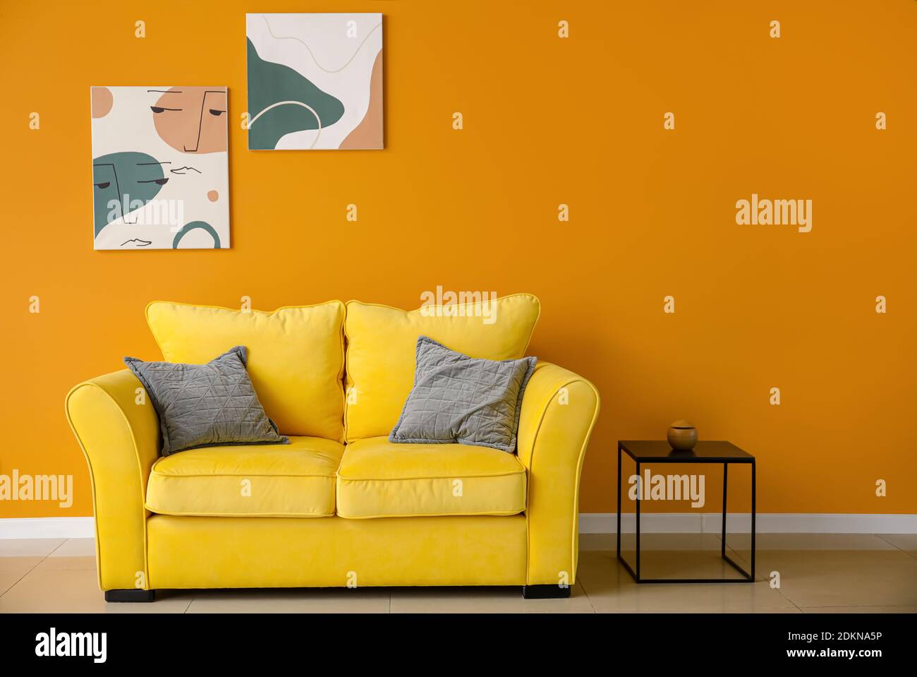 Stylish interior of living room with colorful sofa, table and pictures ...