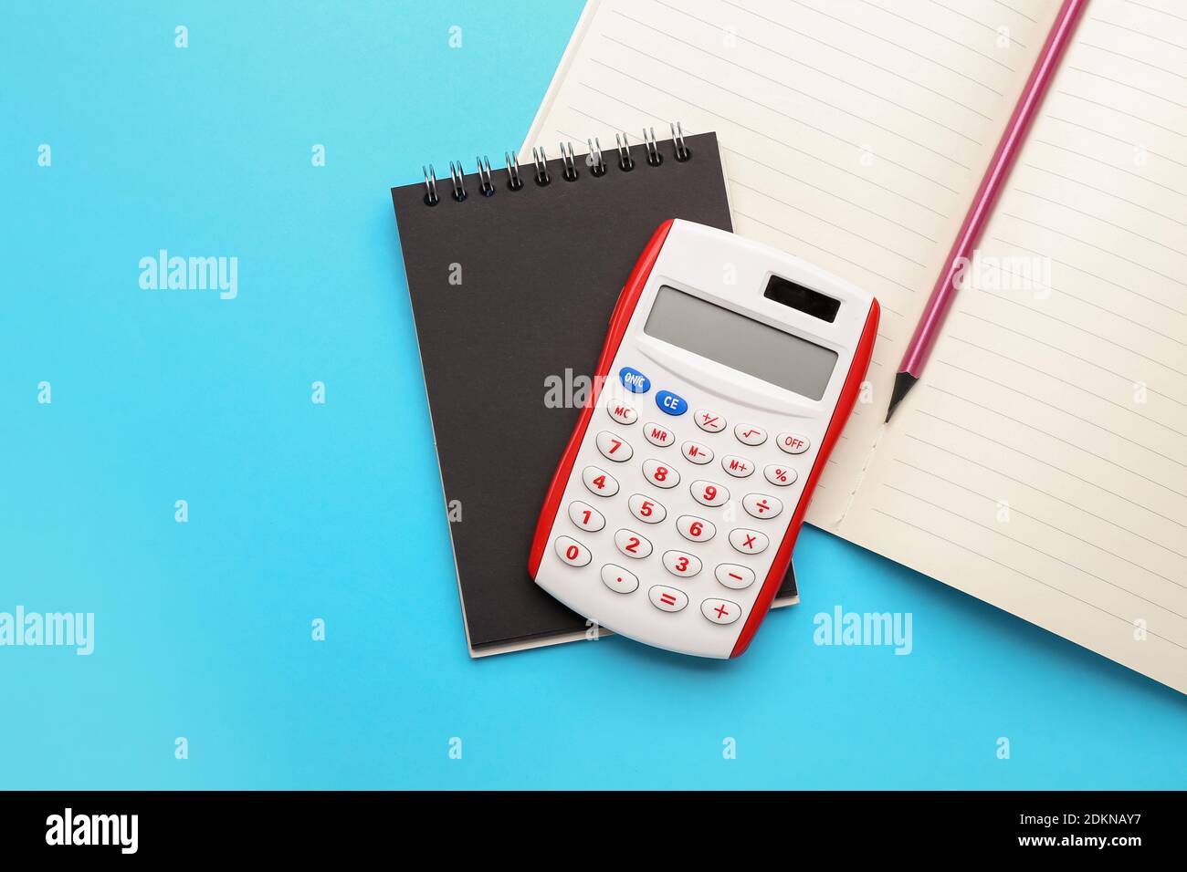 Digital calculator, notebooks and pencil on color background Stock ...