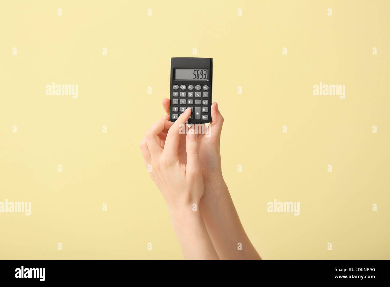 Female hands with calculator on color background Stock Photo - Alamy