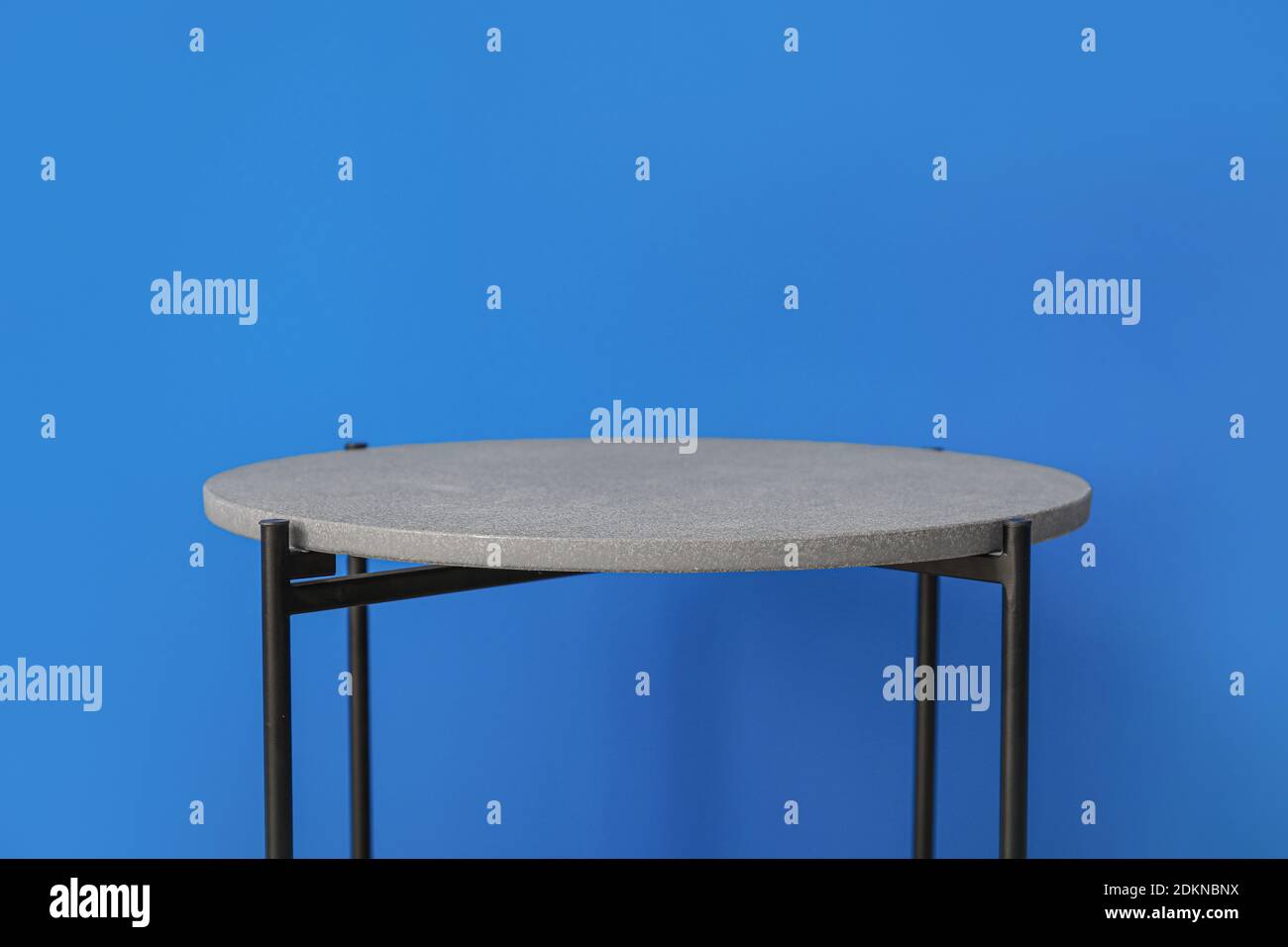 Stylish table near color wall Stock Photo - Alamy