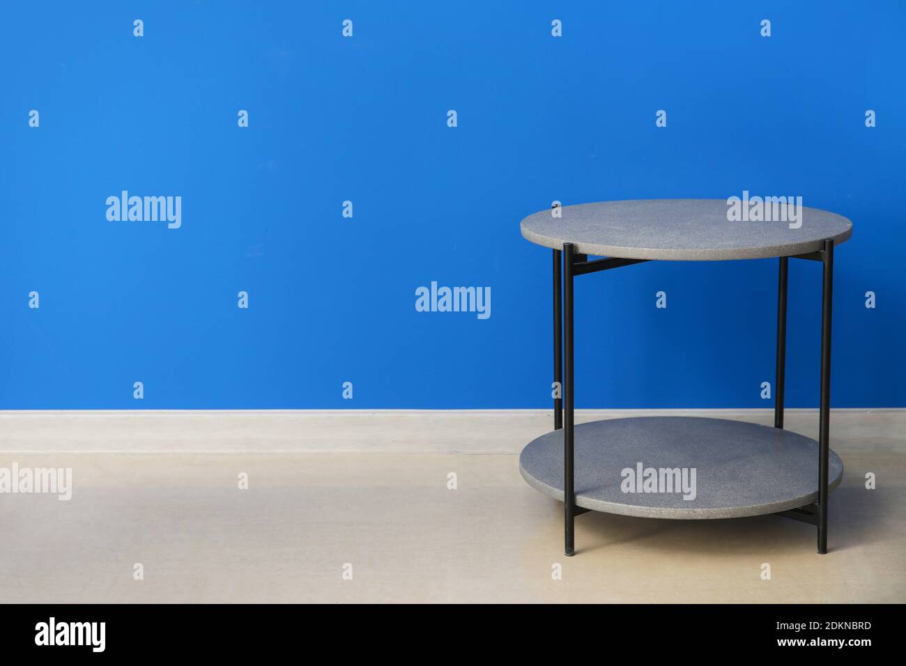 Stylish table near color wall Stock Photo - Alamy