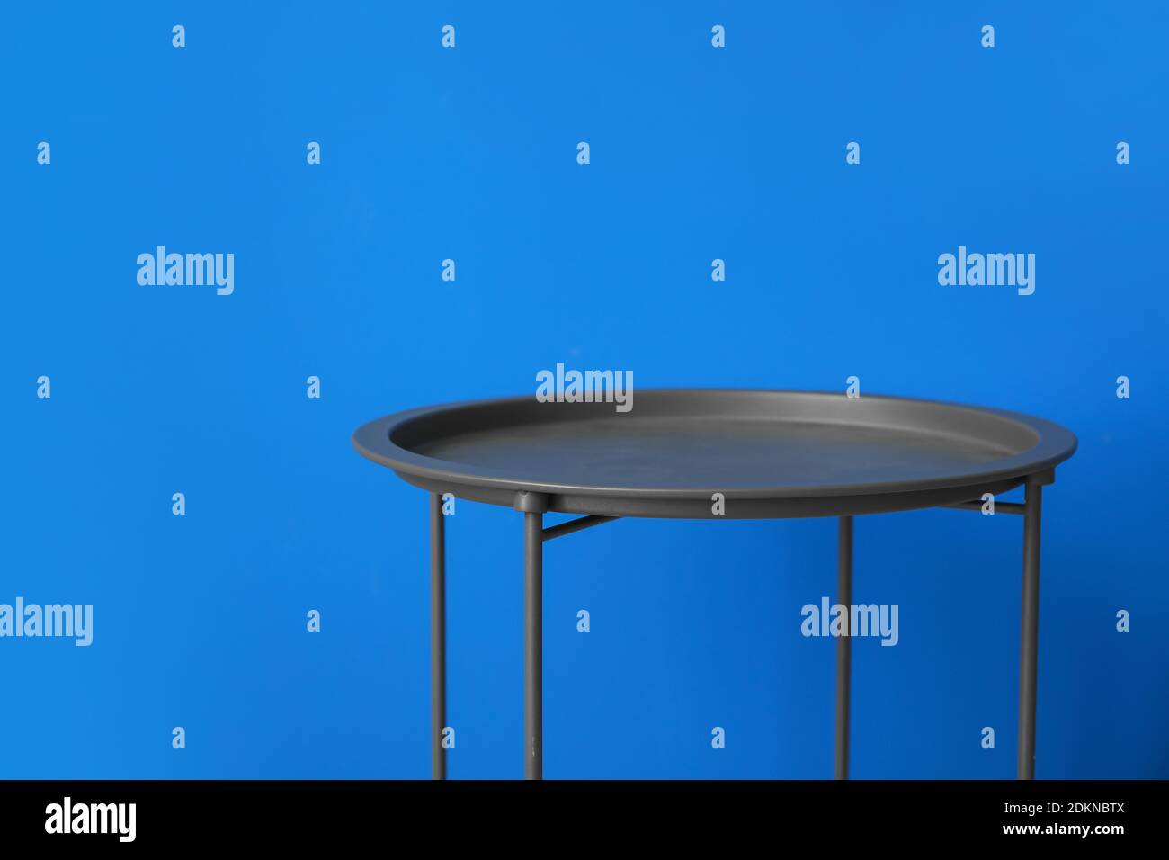 Stylish table near color wall Stock Photo - Alamy