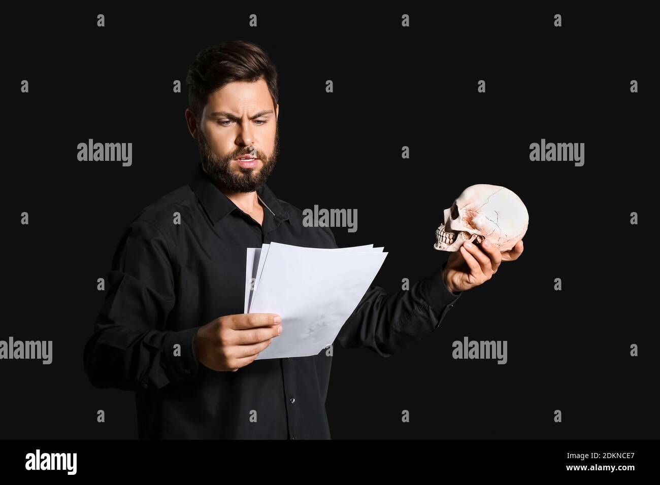 Male actor with human skull on dark background Stock Photo - Alamy
