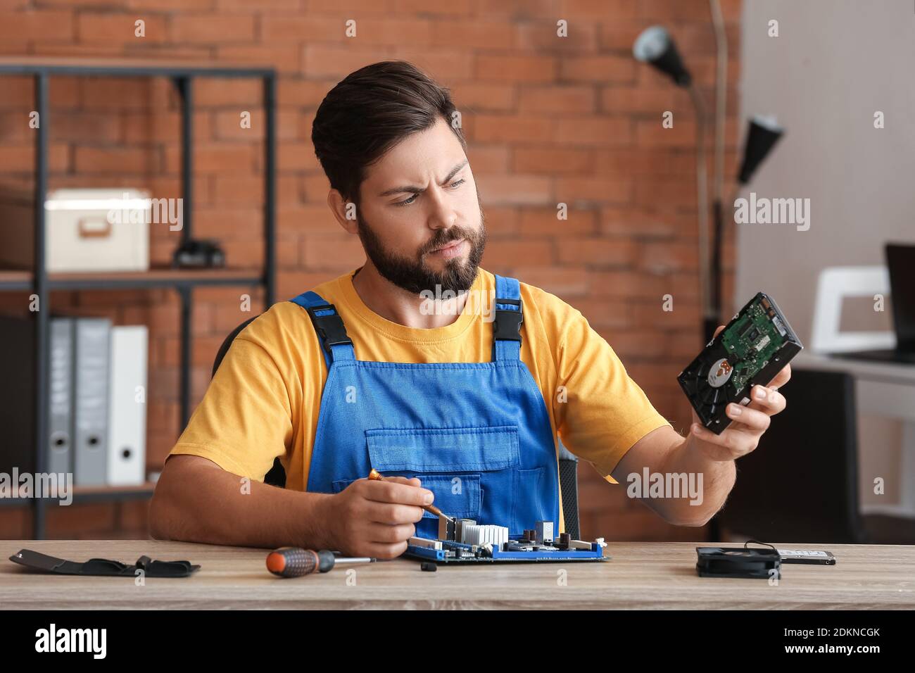 Technician repairing computer in service center Stock Photo - Alamy