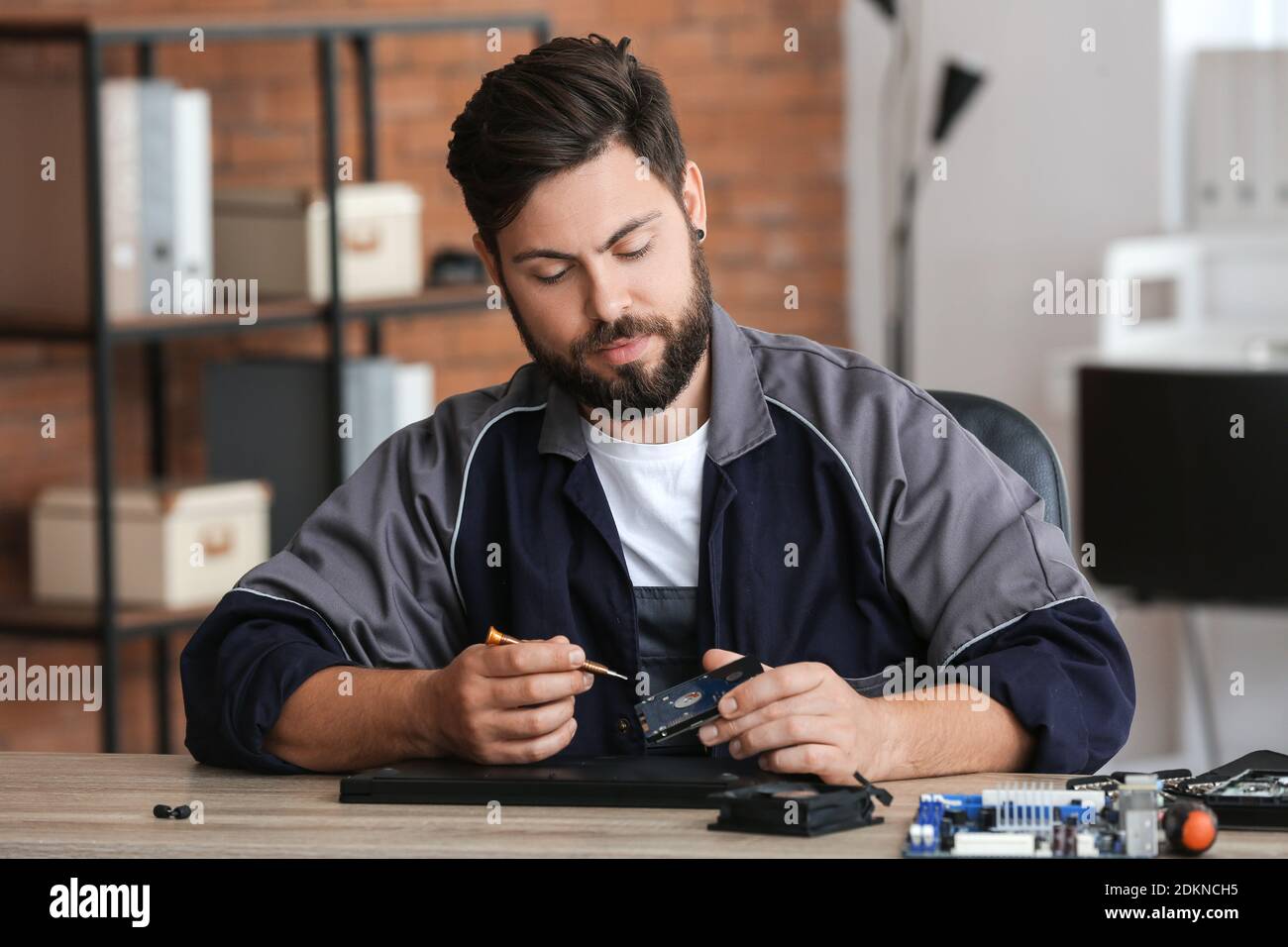 Technician repairing computer in service center Stock Photo - Alamy