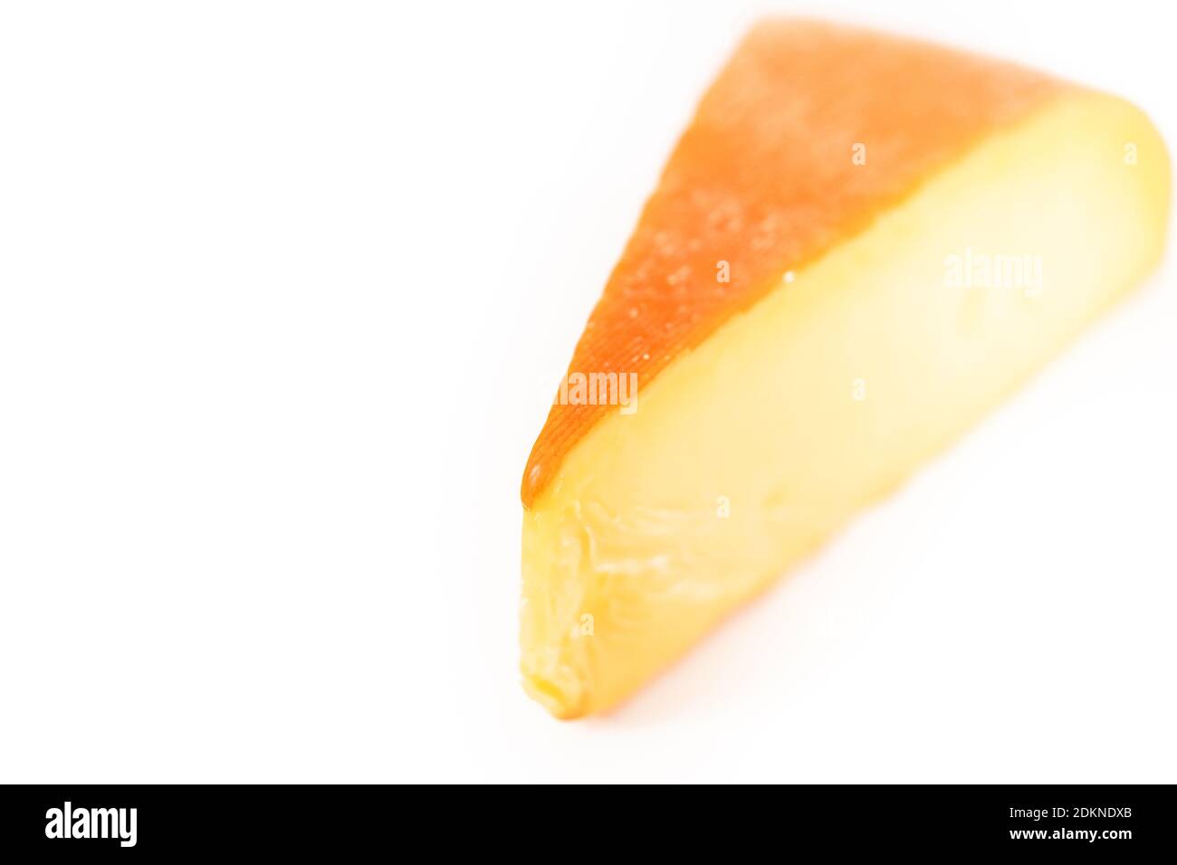 Large slice of smoked gouda cheese on a white background Stock Photo ...