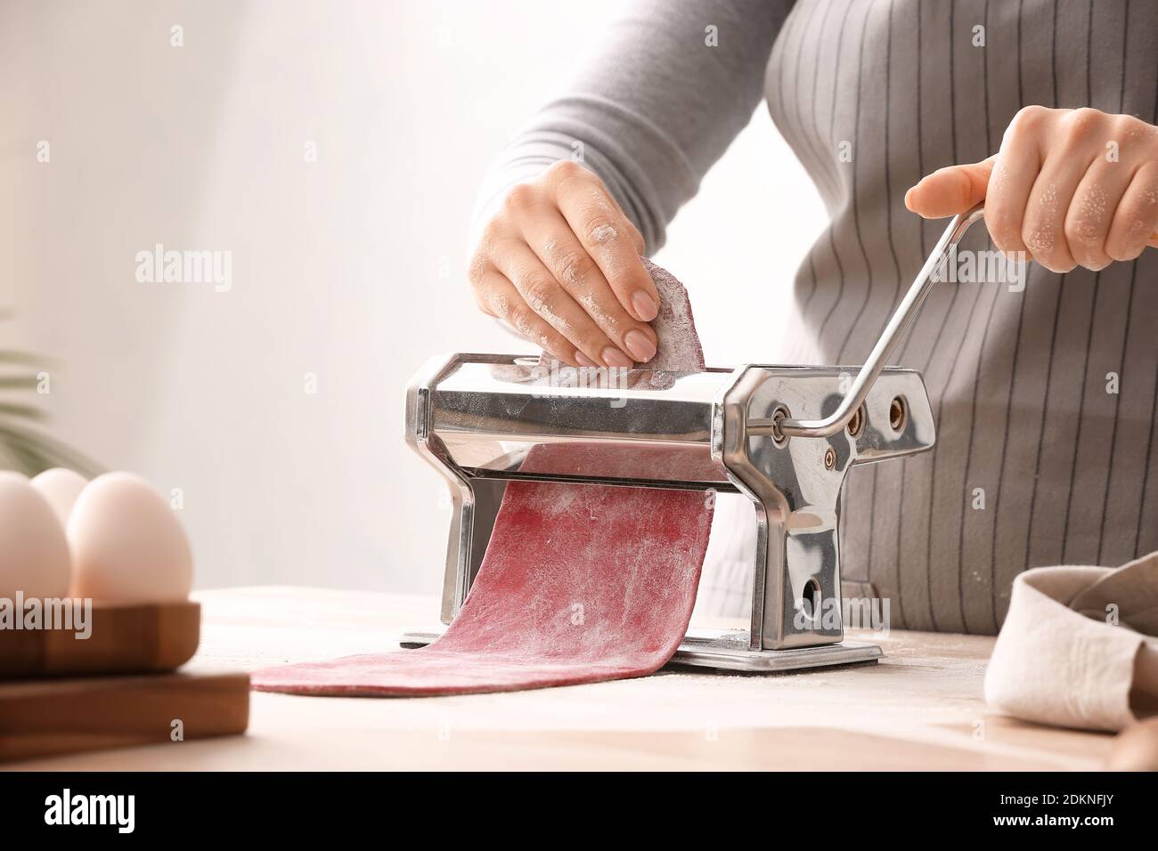 Woman making dough for pasta with machine at table Stock Photo - Alamy