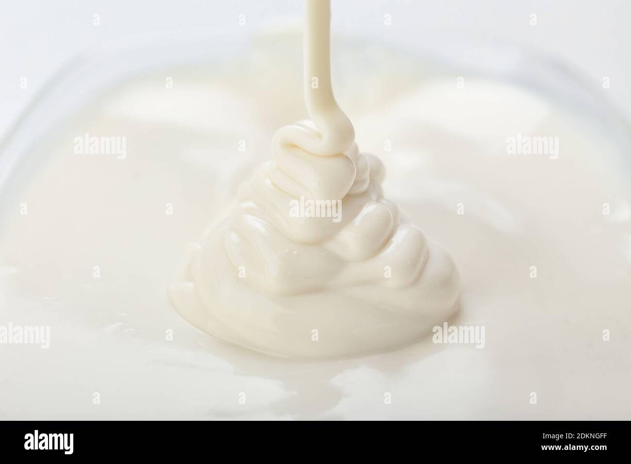 Liquid white chocolate on white background Stock Photo - Alamy
