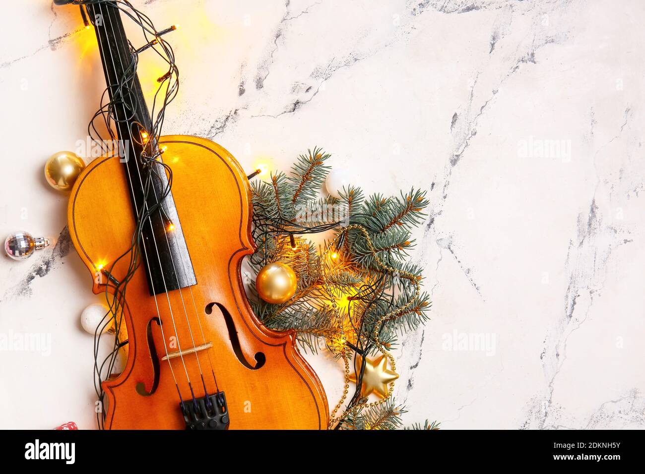Violin with Christmas lights and decor on light background Stock Photo ...