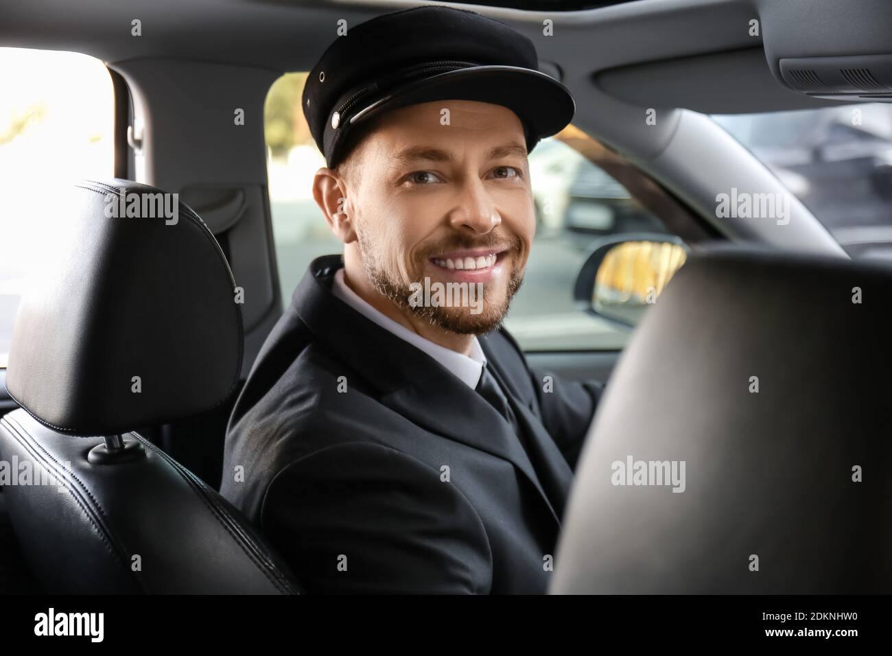 Handsome chauffeur driving luxury car Stock Photo - Alamy