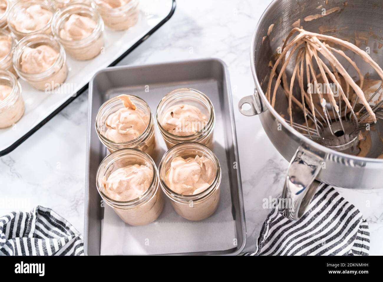 Scooping mixture into the small glass jars to make homemade chocolate ...