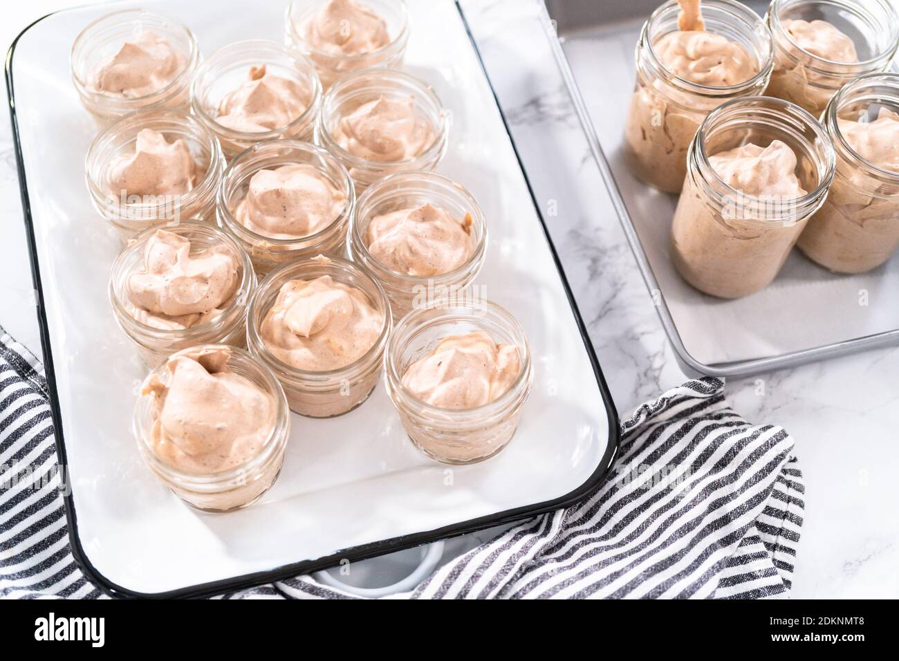 Scooping mixture into the small glass jars to make homemade chocolate ...