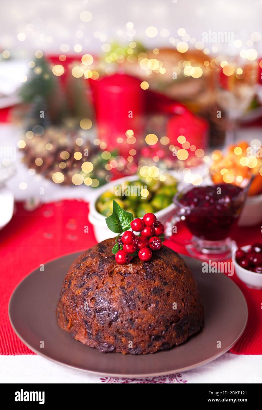 Traditional Christmas pudding with holly on top on a Christmas dinner ...