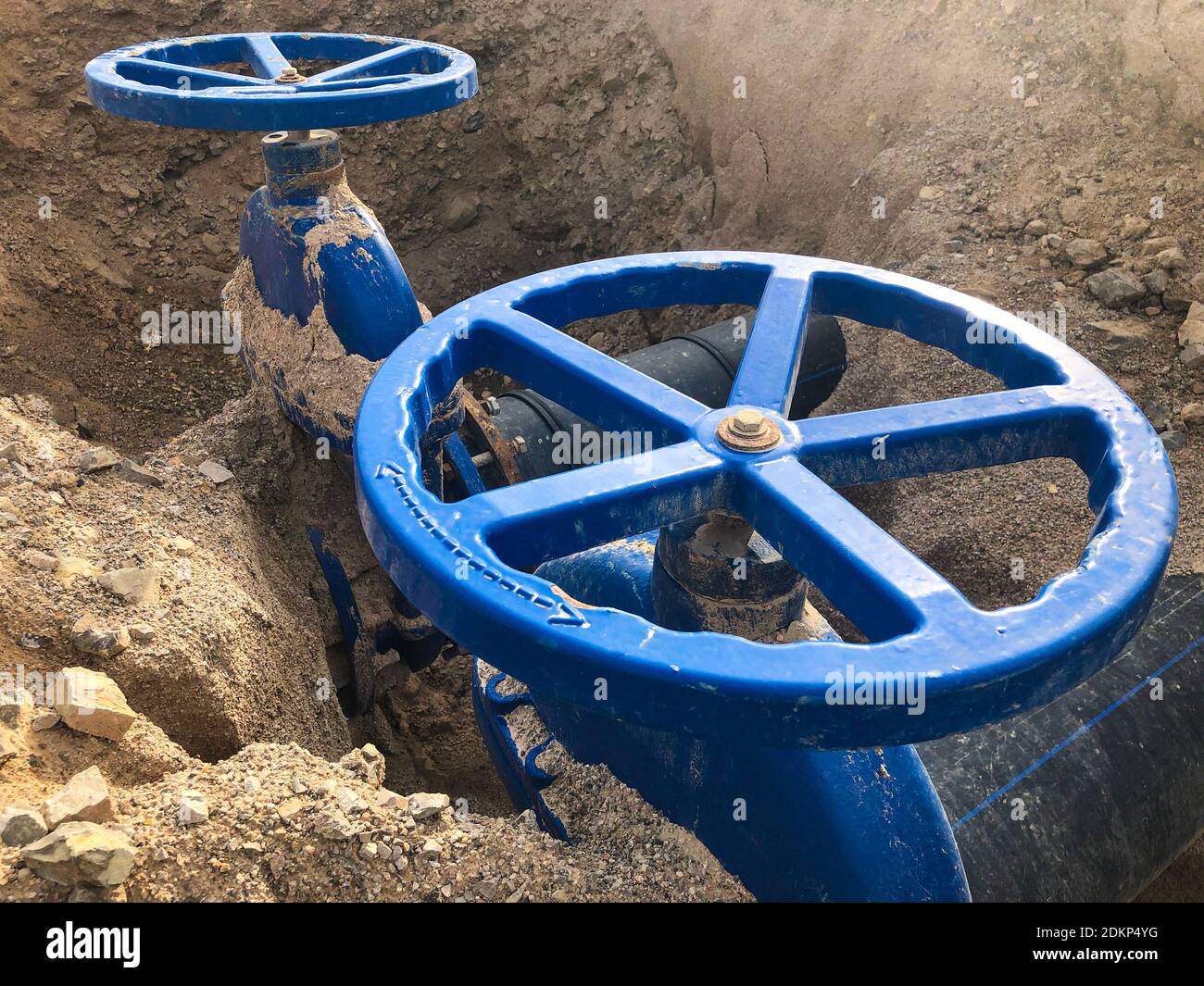 Valves on pipeline in ground. Pipe valves in trench Stock Photo - Alamy