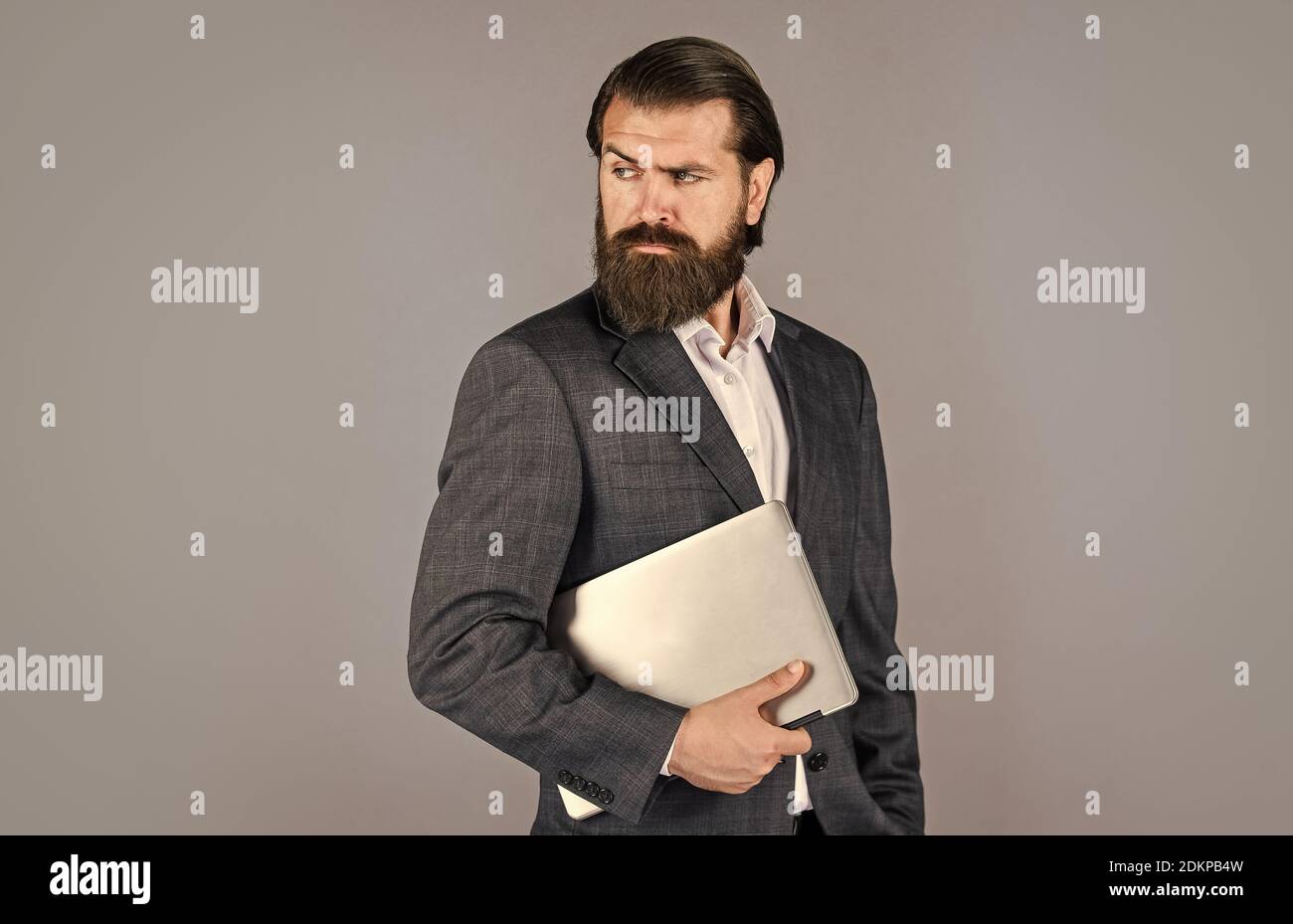 confident businessman with laptop. brutal male with beard in suit ...