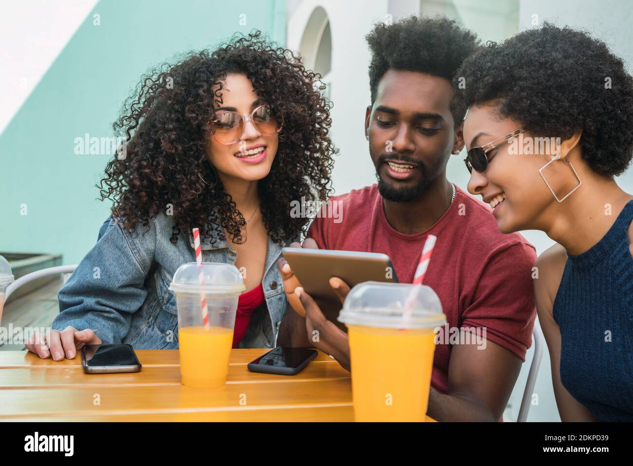 Three afro friends using digital tablet Stock Photo - Alamy
