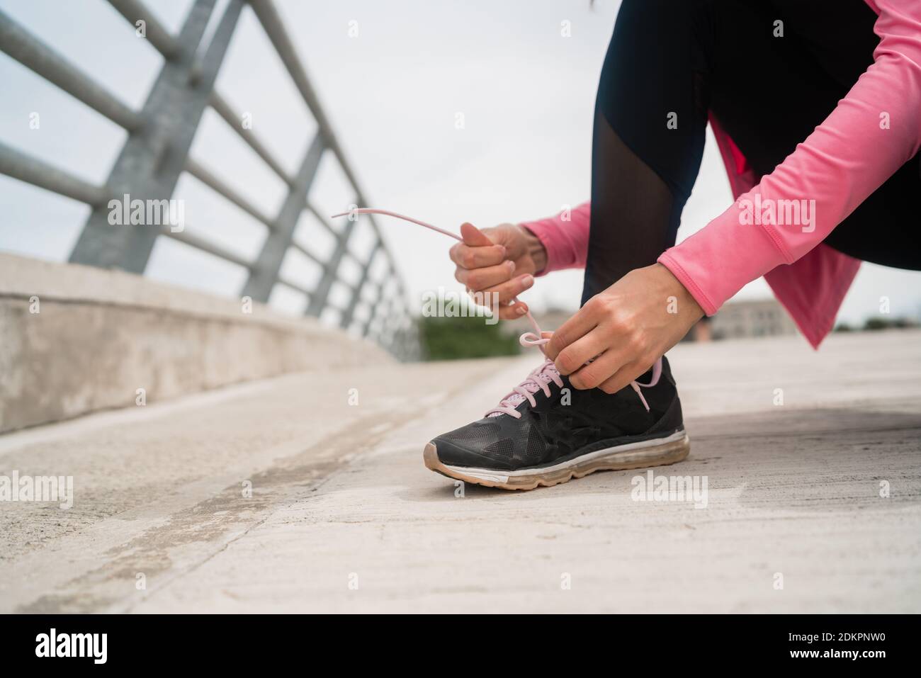Athletic woman tying her shoelaces Stock Photo - Alamy