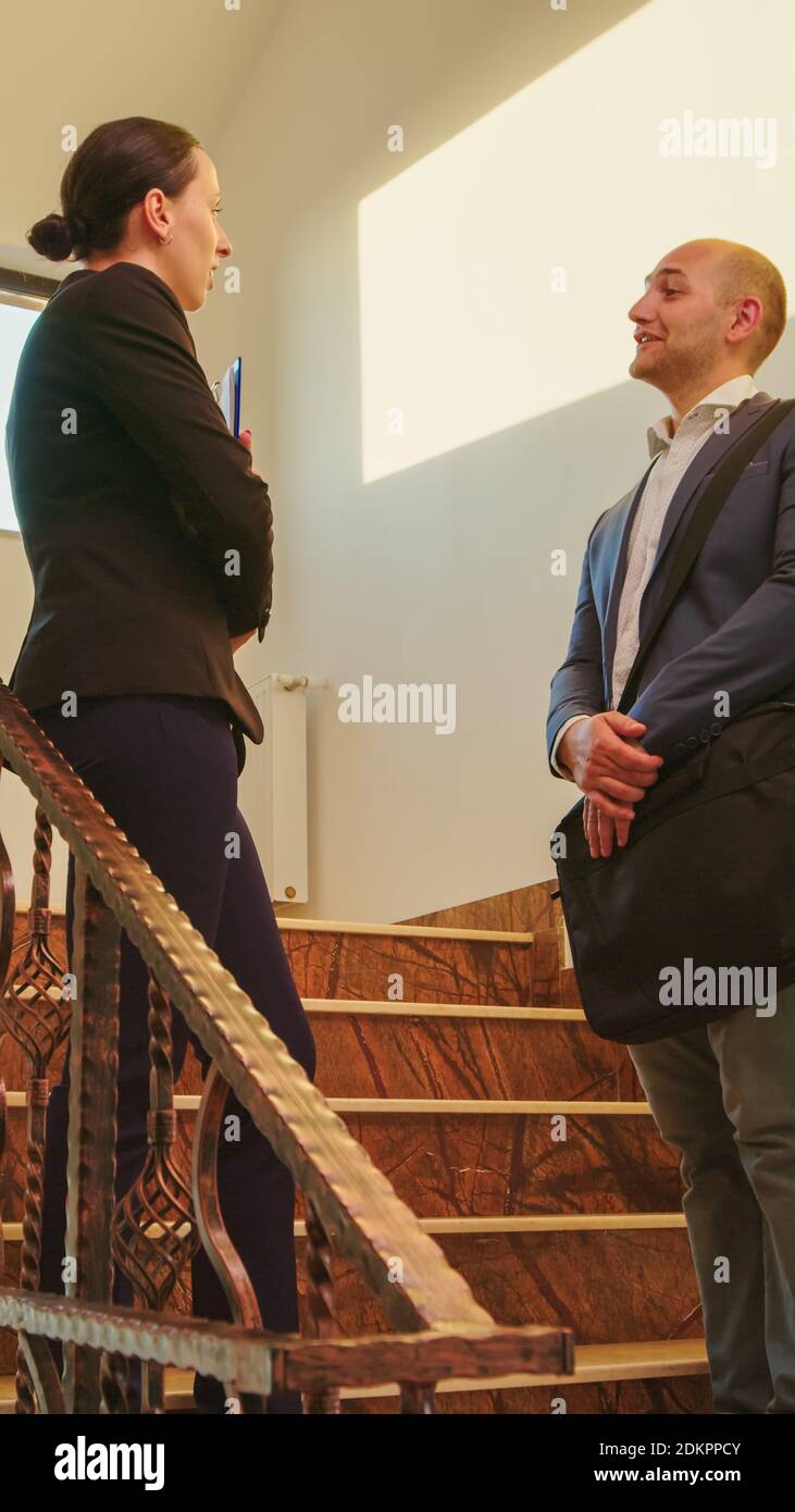 Businesswoman meeting man colleague in corporate office greeting with ...