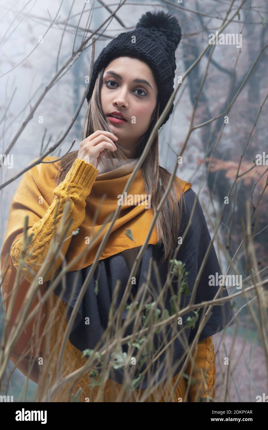 A YOUNG WOMAN ON A CHILLY DAY POSING NEAR DRIED BRANCHES Stock Photo ...