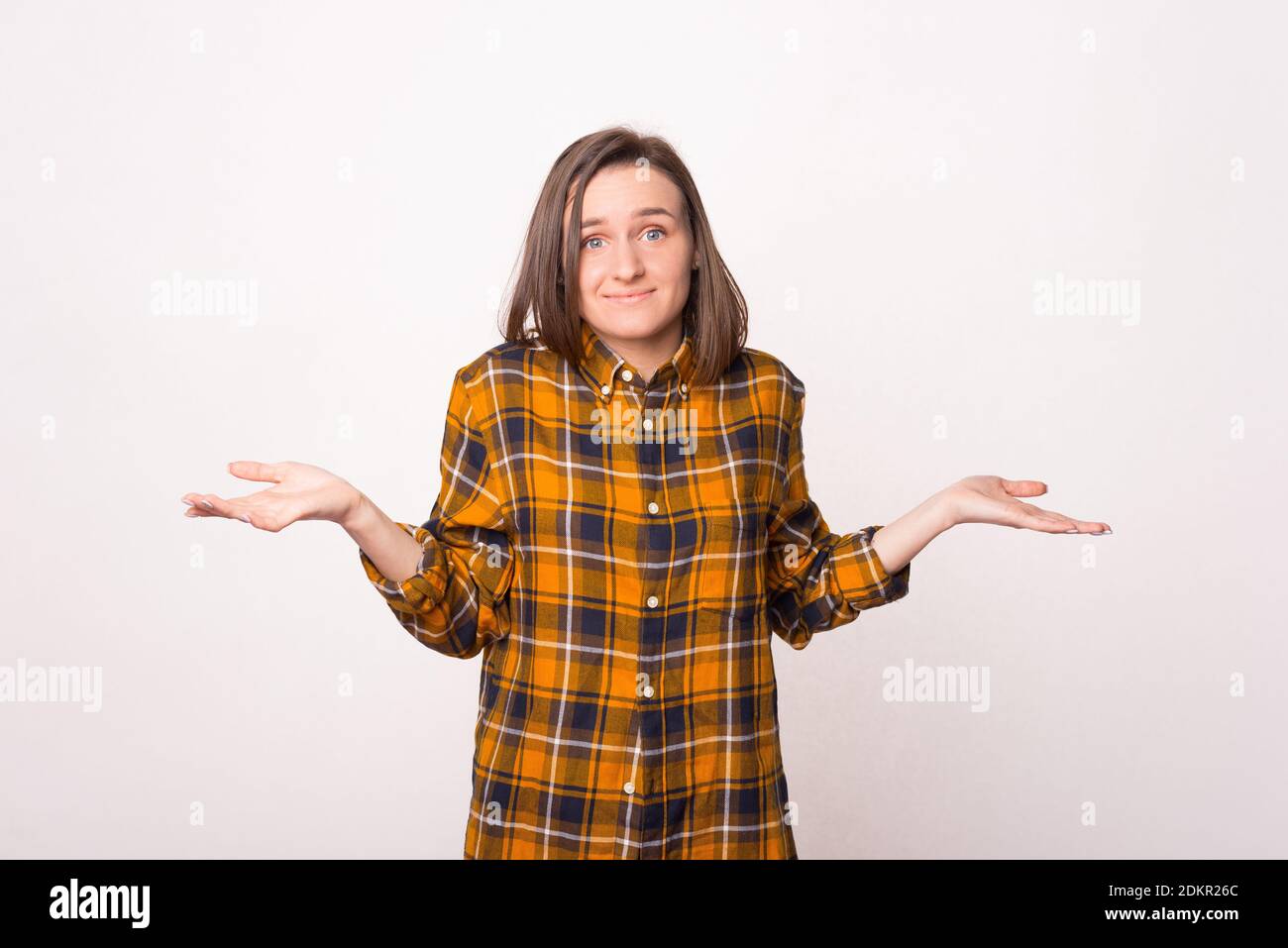 Unsure young woman is gesturing over white background Stock Photo - Alamy