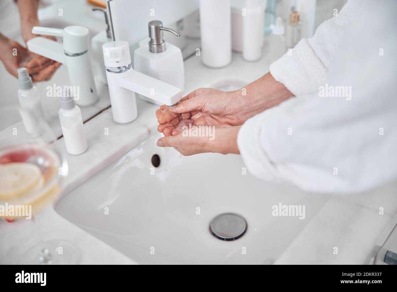 Young female washing arm under the water tap Stock Photo - Alamy