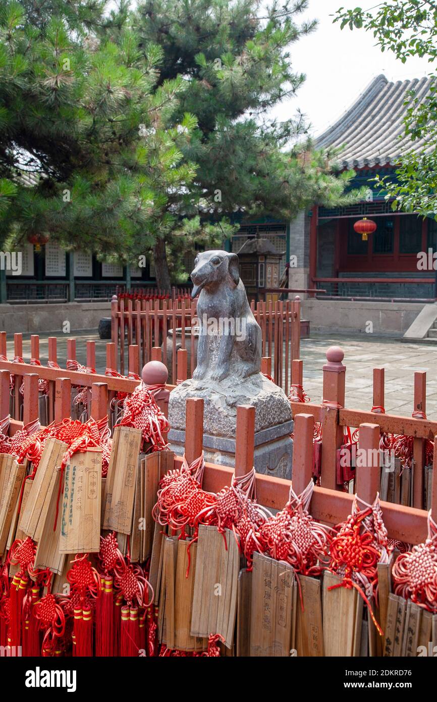 Red Chinese prayer sticks with statue for Year of the Dog near Great ...