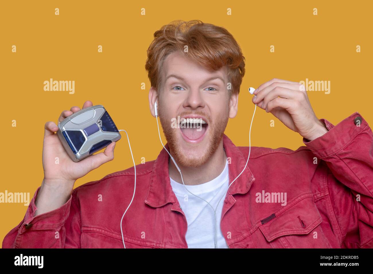 Young bearded good-looking man in red jacket with old player looking ...
