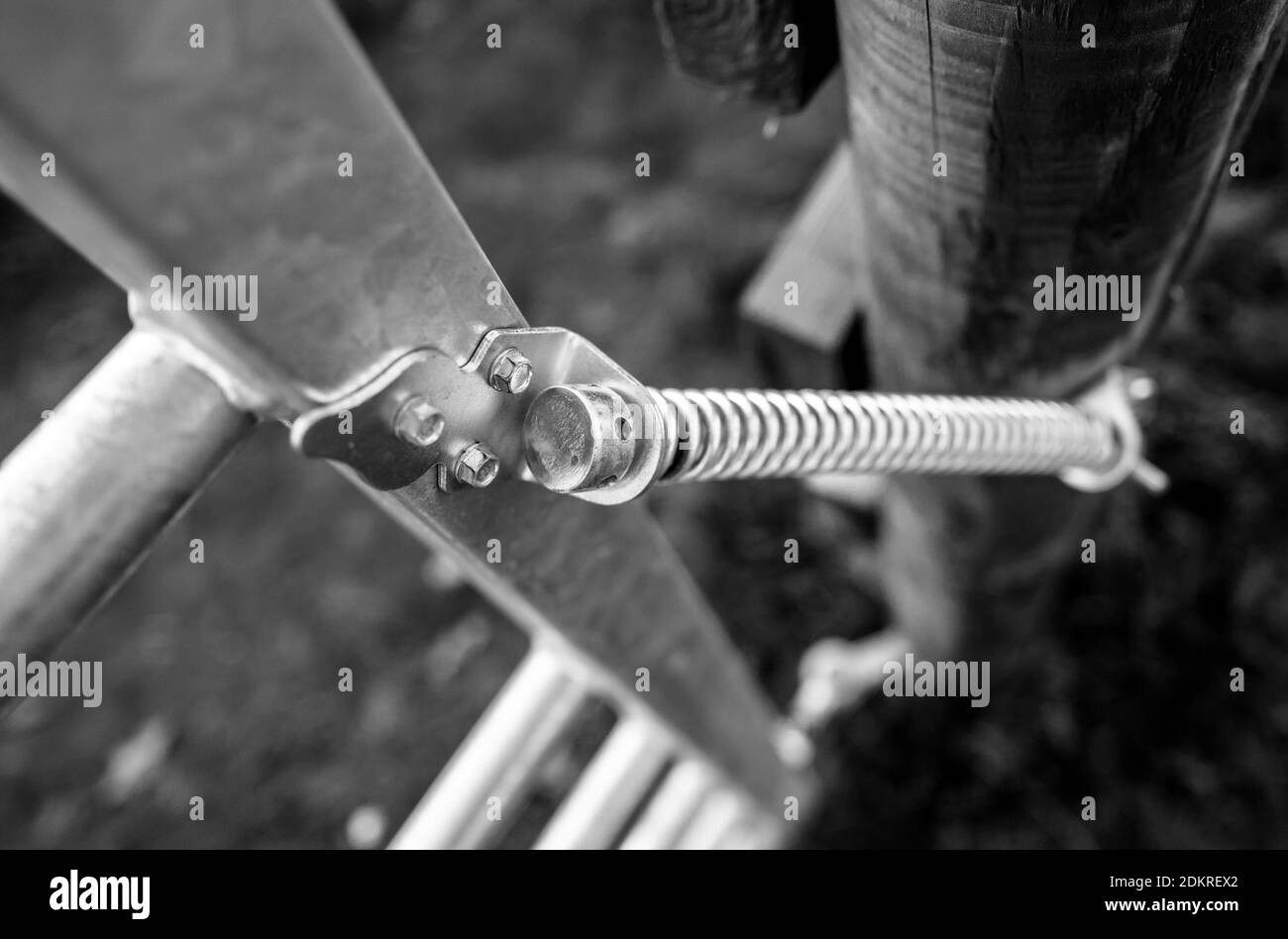 Spring loaded galvanised metal gate attached to a wooden post Stock ...