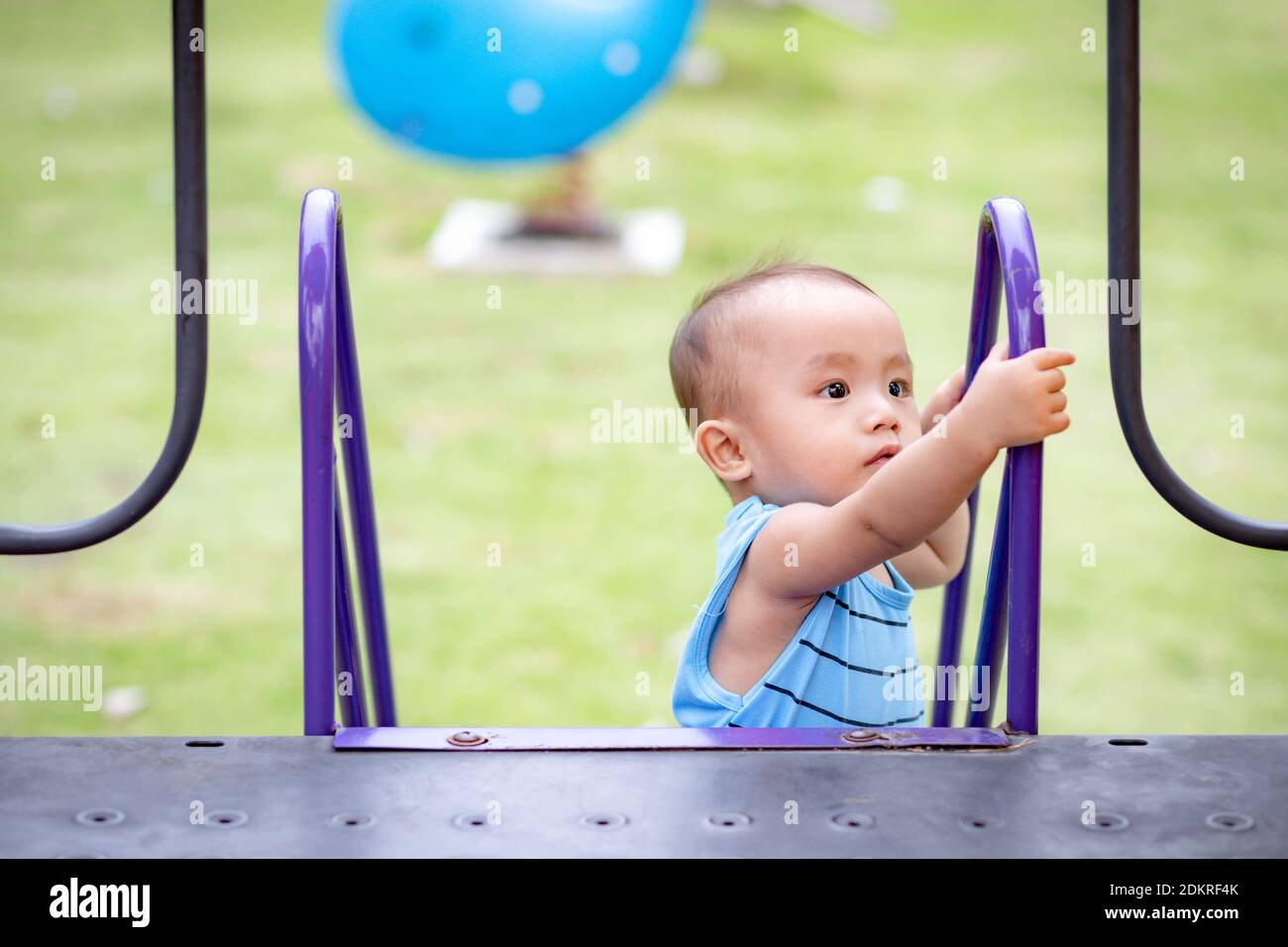 Cute Baby Boy Standing On Ladder In Playground Stock Photo - Alamy