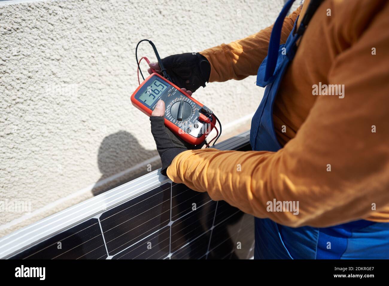 Male worker installing solar photovoltaic panel system on roof of ...