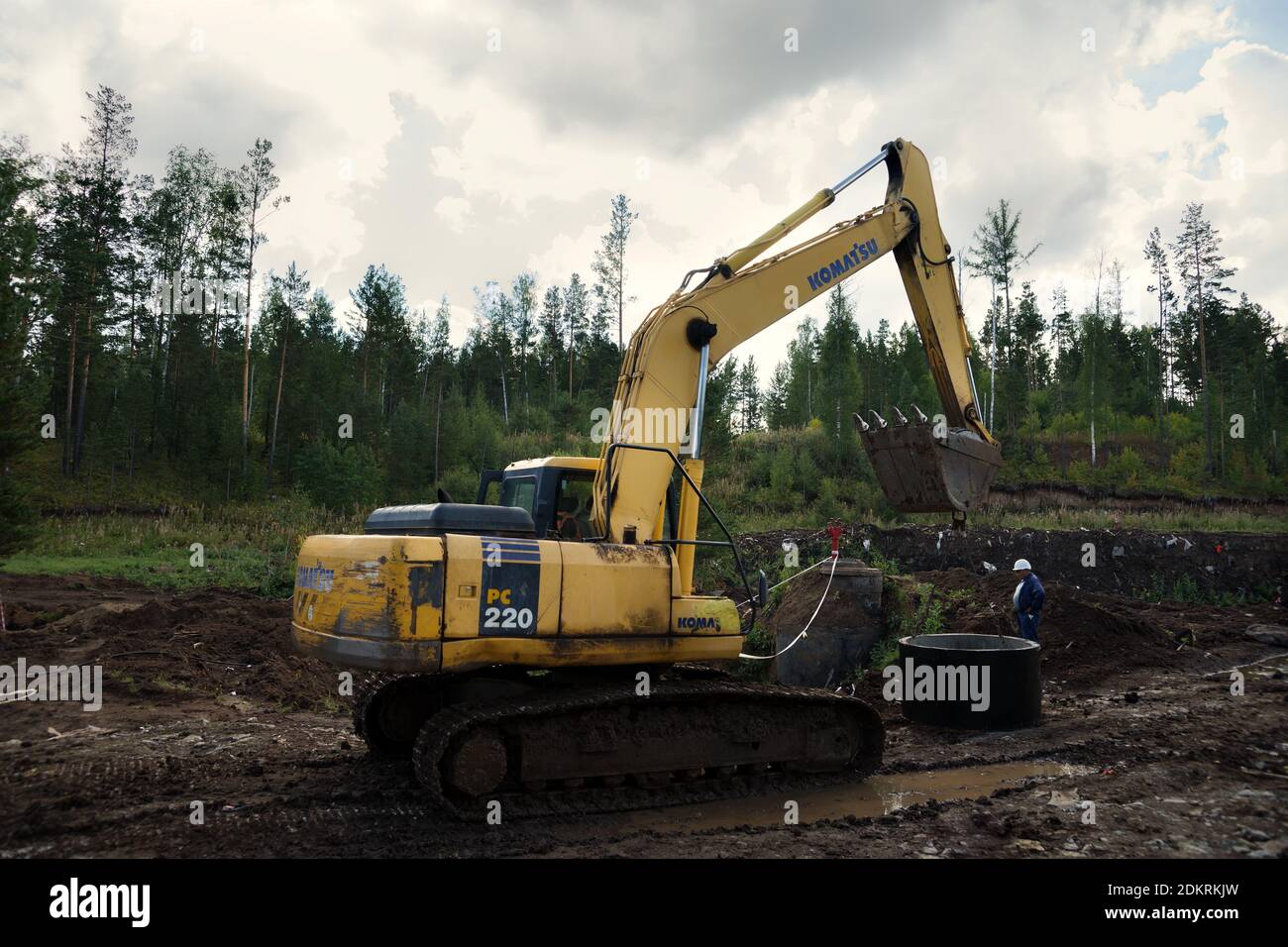 The crawler-mounted power shovel is carrying a concrete ring to install ...