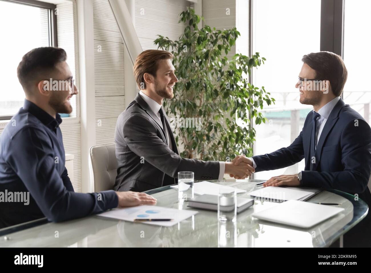 Smiling international businessmen handshake closing deal at meeting ...