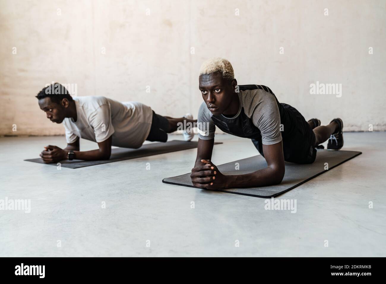 Two young handsome african american men stretching their bodies while ...