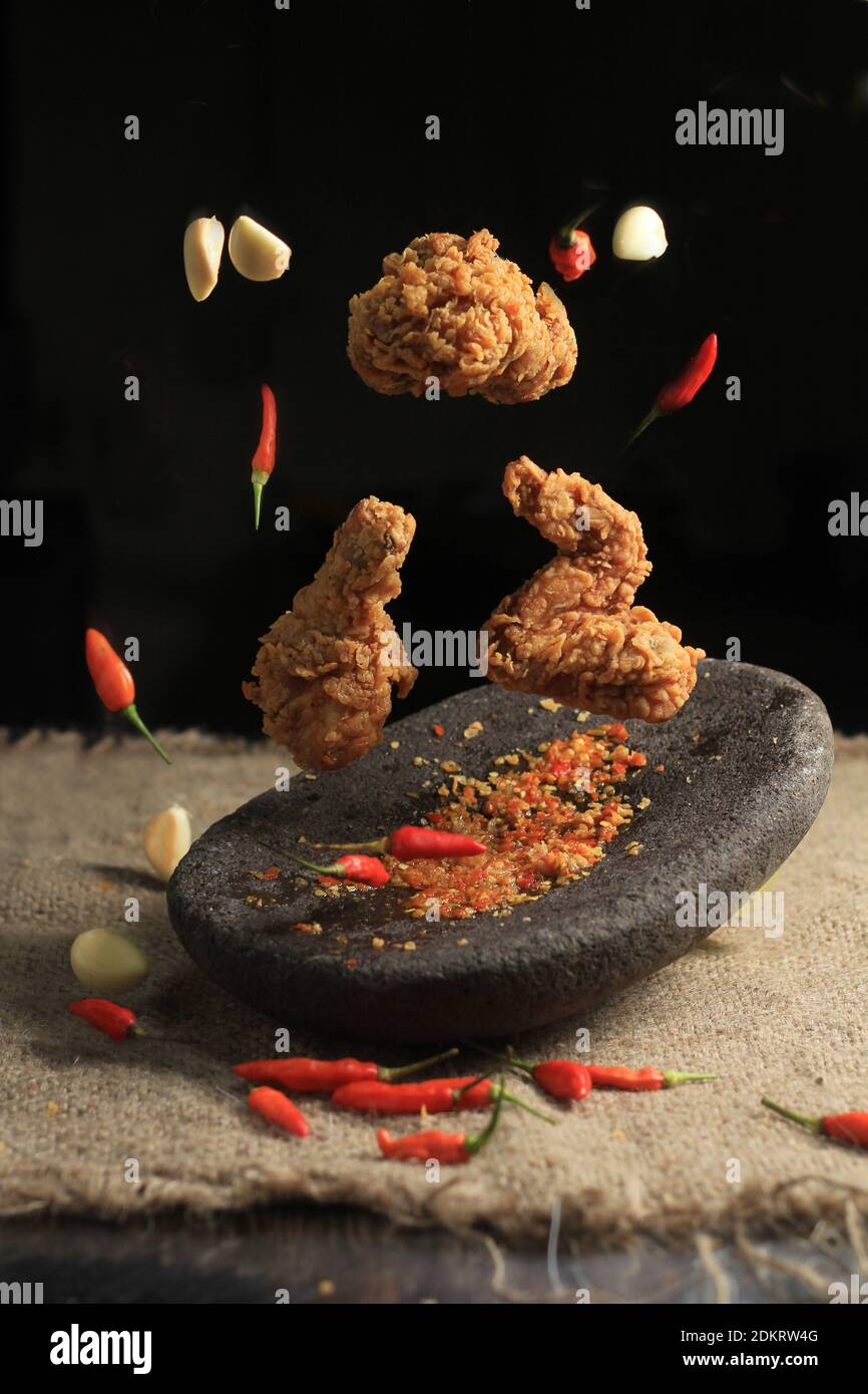 flying fried chicken on stone mortar with chili and garlic Stock Photo ...