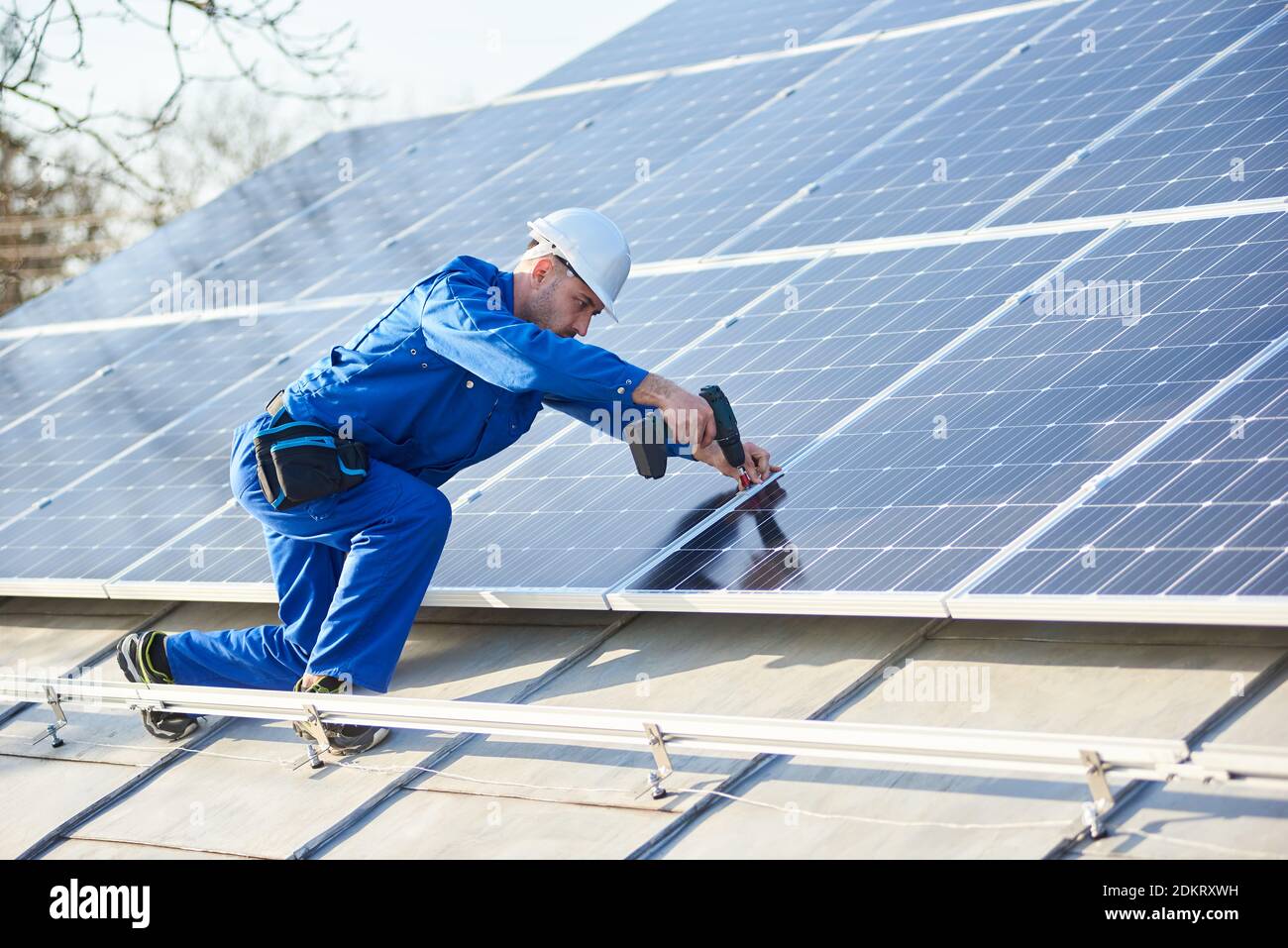 Male engineer in blue suit and protective helmet installing solar ...