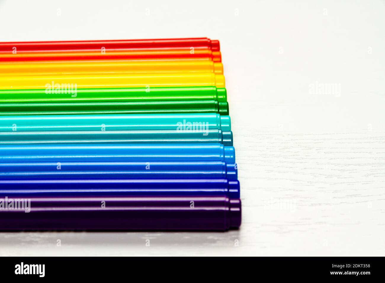 bright colored markers without caps lie on a white wooden table Stock ...