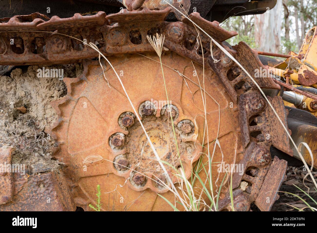 A close up of mud filled and rusted caterpillar tracks on an old ...